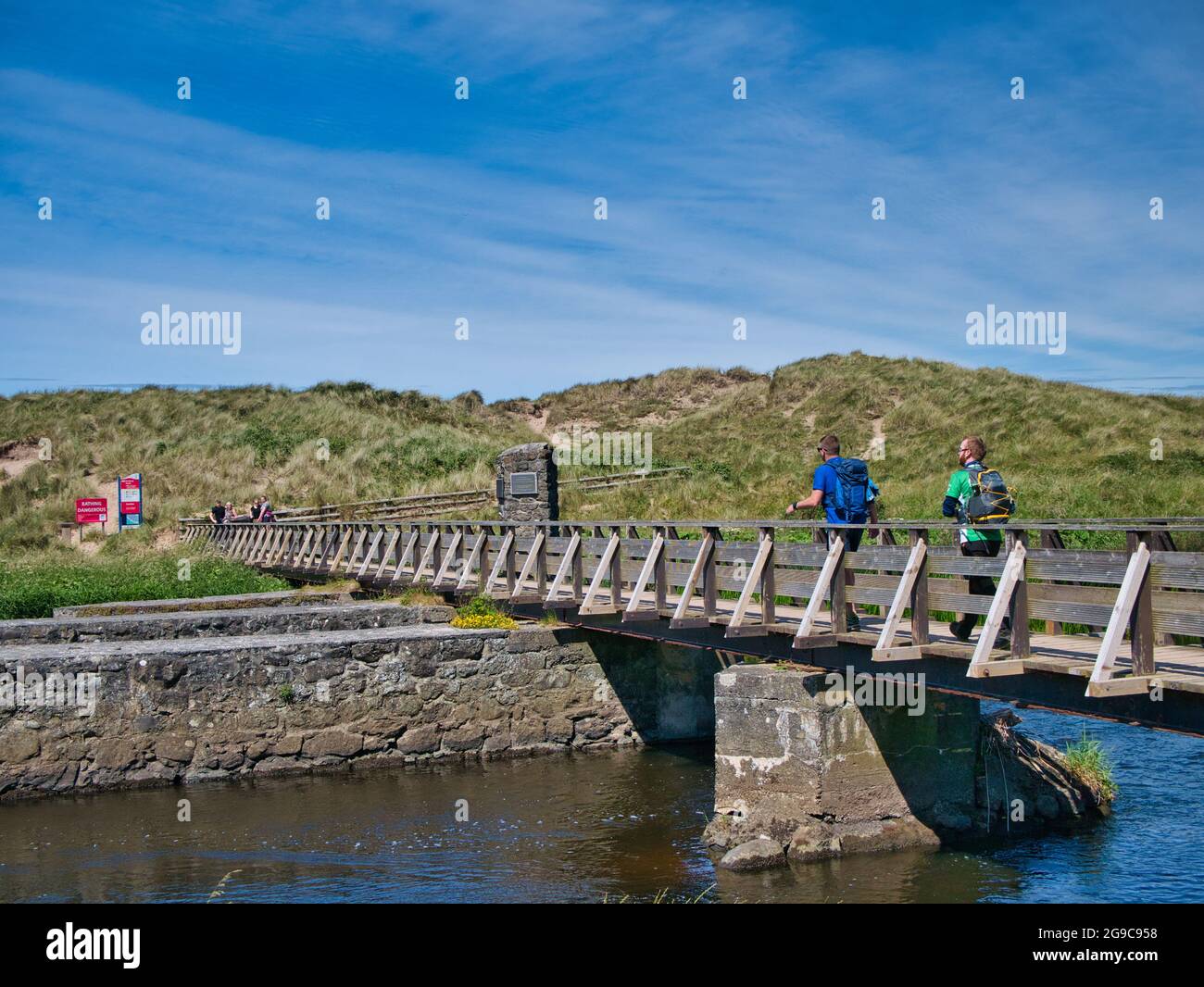 Two walkers cross the Three Quarter Mile wooden footbridge over the ...