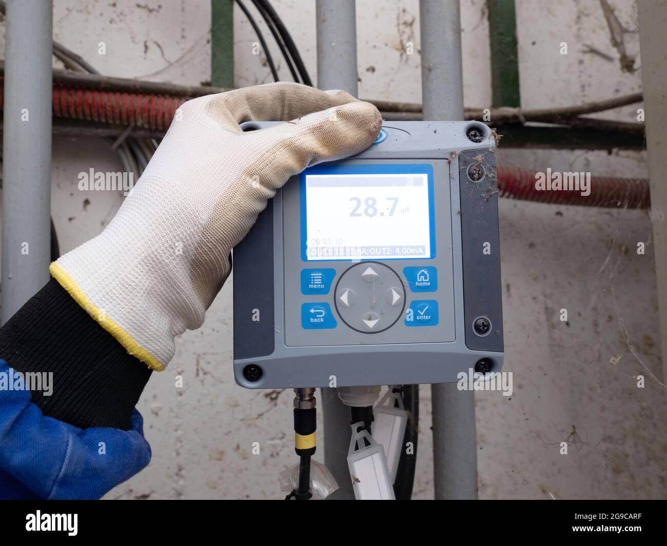 The industrial control panel shows the current temperature. Buttons ...