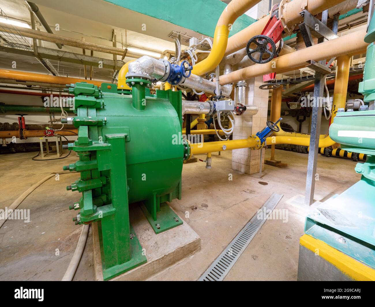 Green pressure tank connected to the piping system. Lots of colorful ...