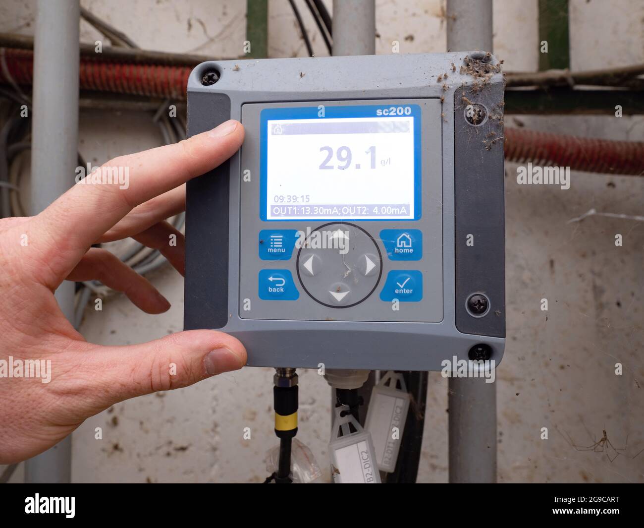 The industrial control panel shows the current temperature. Buttons ...