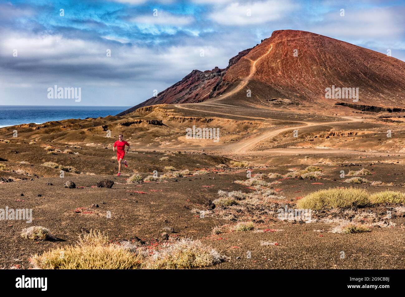 Athlete runner man trail running on volcanic mountain background ...