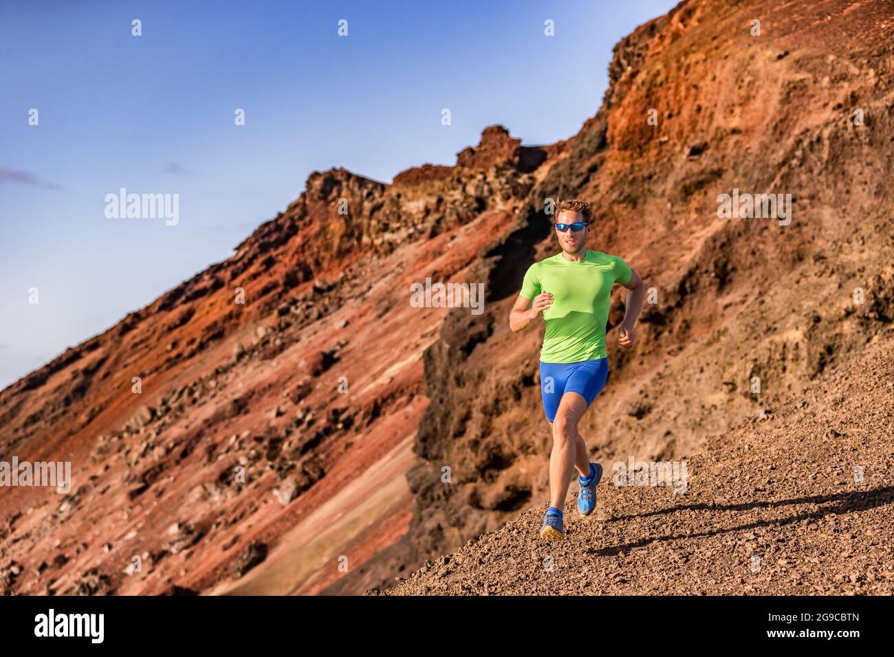 Trail runner man athlete ultra running in mountain rocky path in nature ...