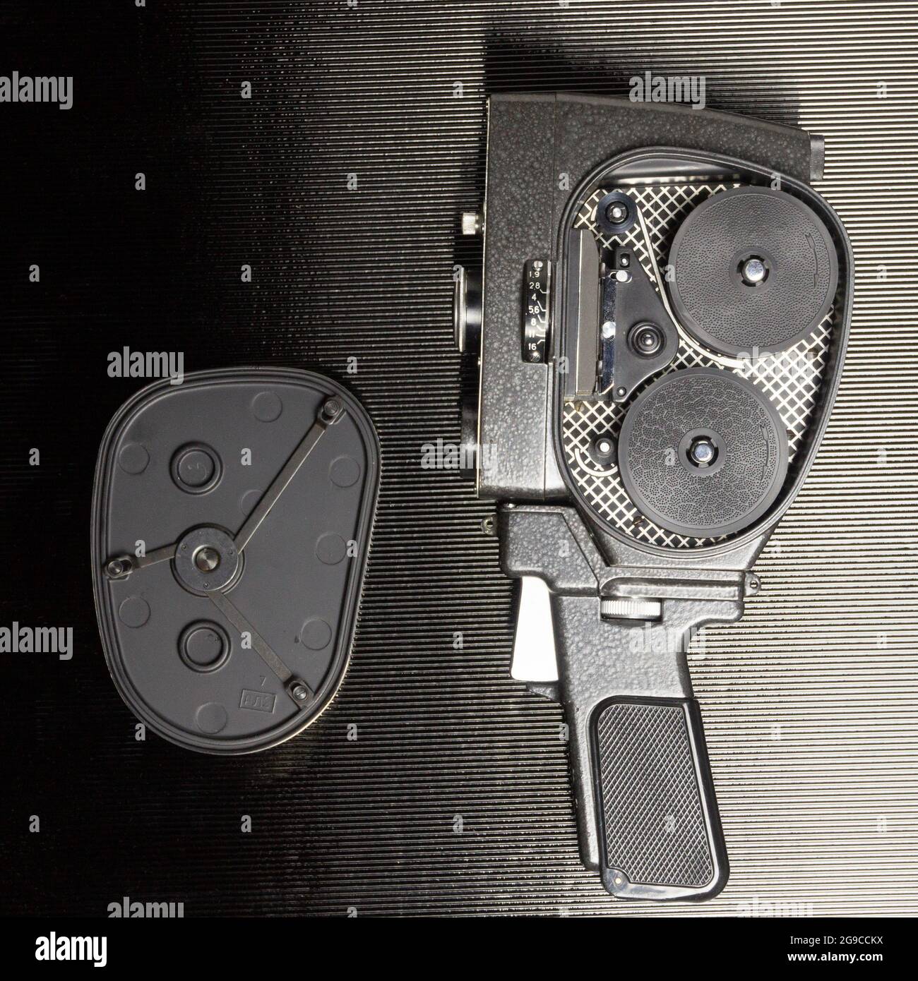 Old amateur movie camera with open cover and spools of roll film on ...