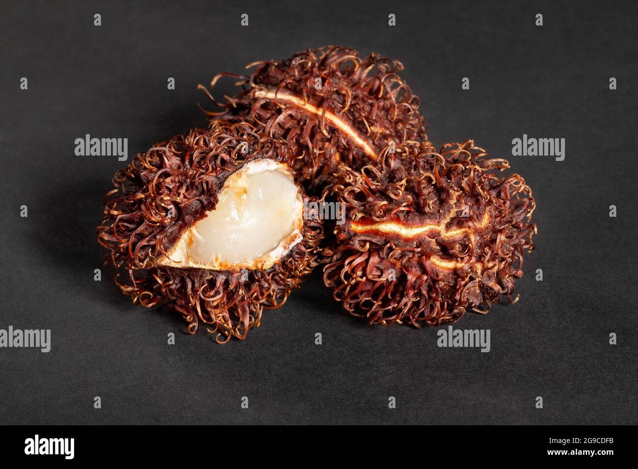 rambutan group on black background Stock Photo - Alamy