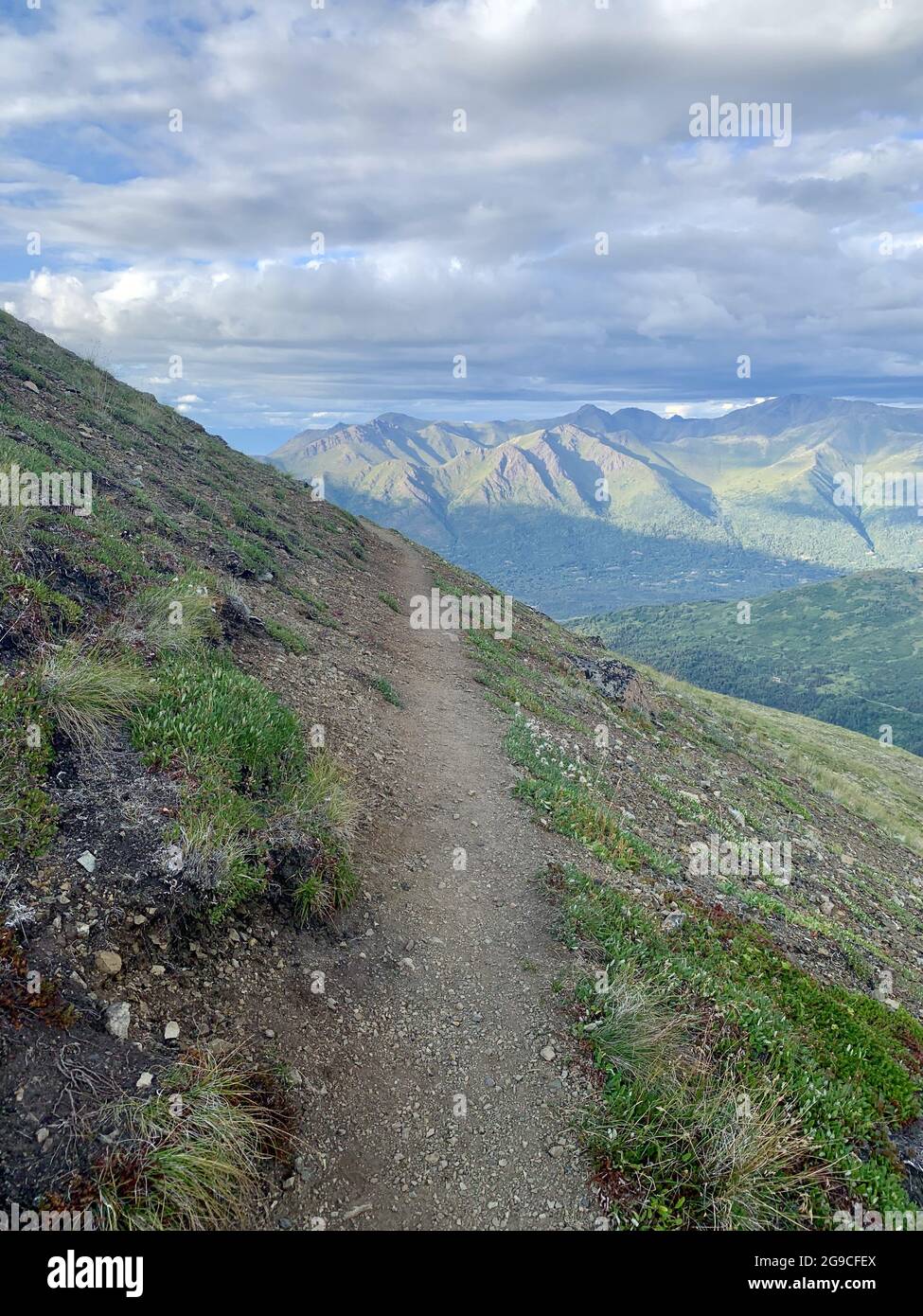 A narrow dirt path on a steep slope at a mountain Stock Photo - Alamy