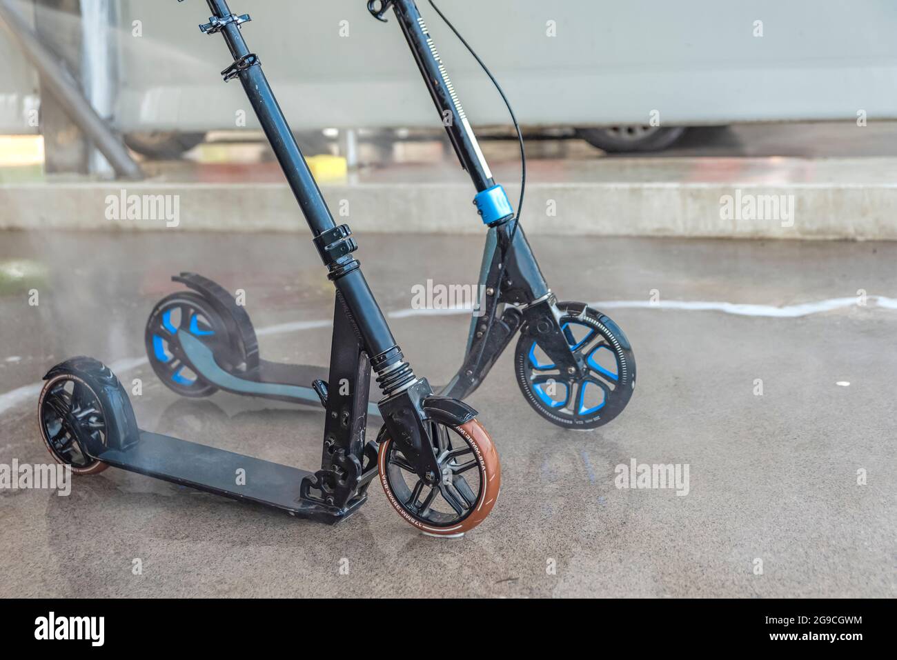 Washing a dirty scooter at a car wash under high pressure water. Care ...