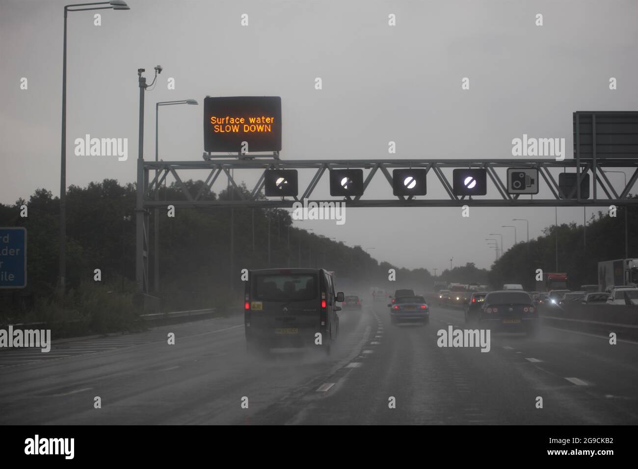 Road sign warning car drivers to slow down and reduce speed on a day of ...