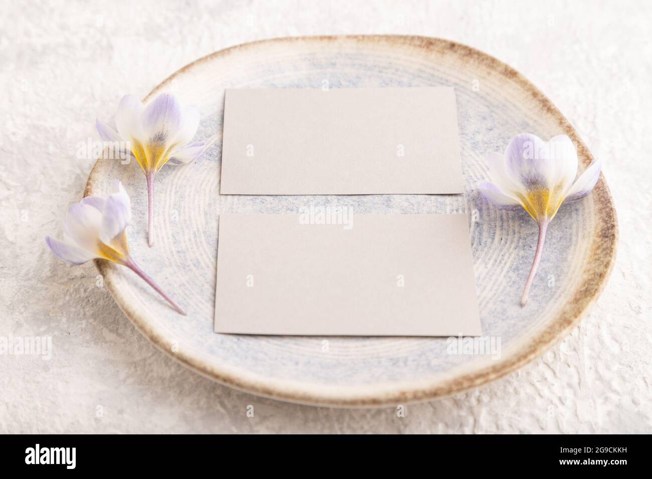 Gray paper invitation card, mockup with crocus flowers on ceramic plate ...