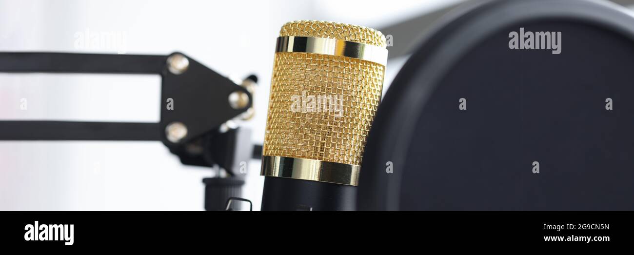 Closeup of golden microphone in recording studio. Radio work concept ...