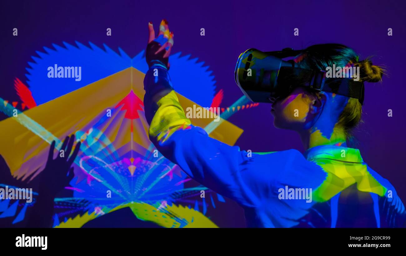 Large screen augmented reality experience - woman using VR headset ...