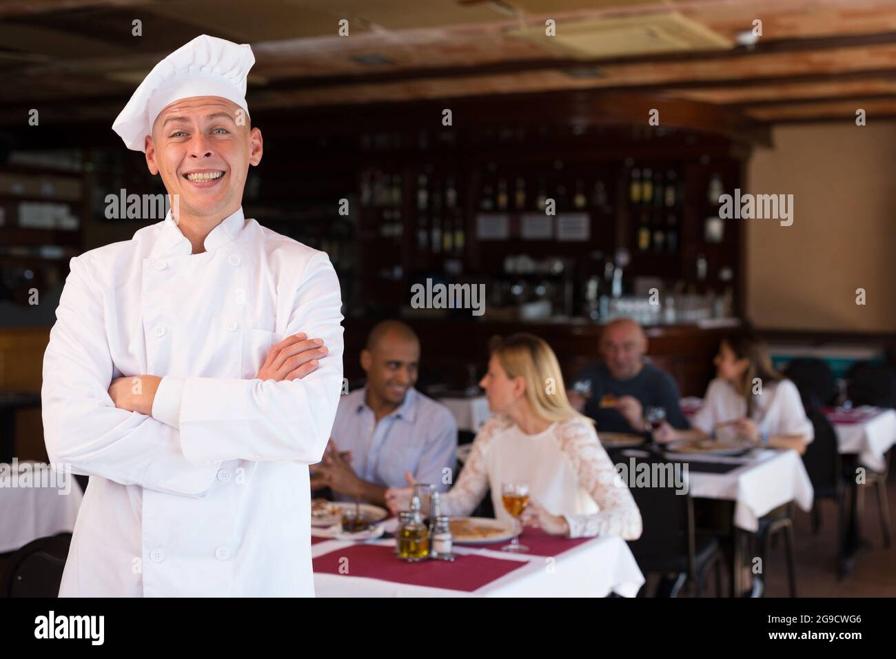 Portrait of chef with crossed arms in restaurant hall Stock Photo - Alamy