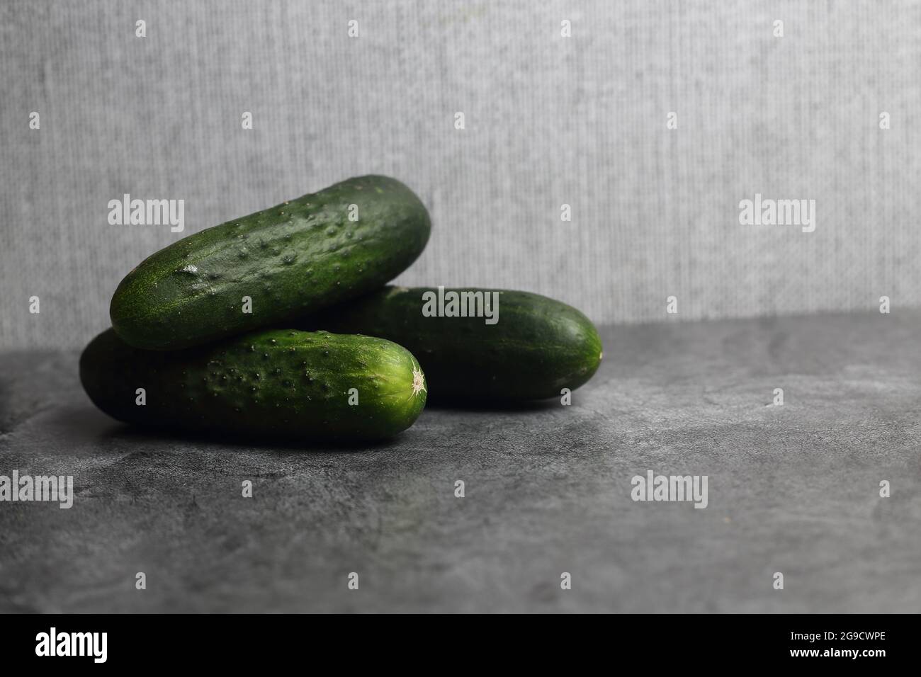 healthy eating concept - a pile of cucumbers isolaed on gray background ...