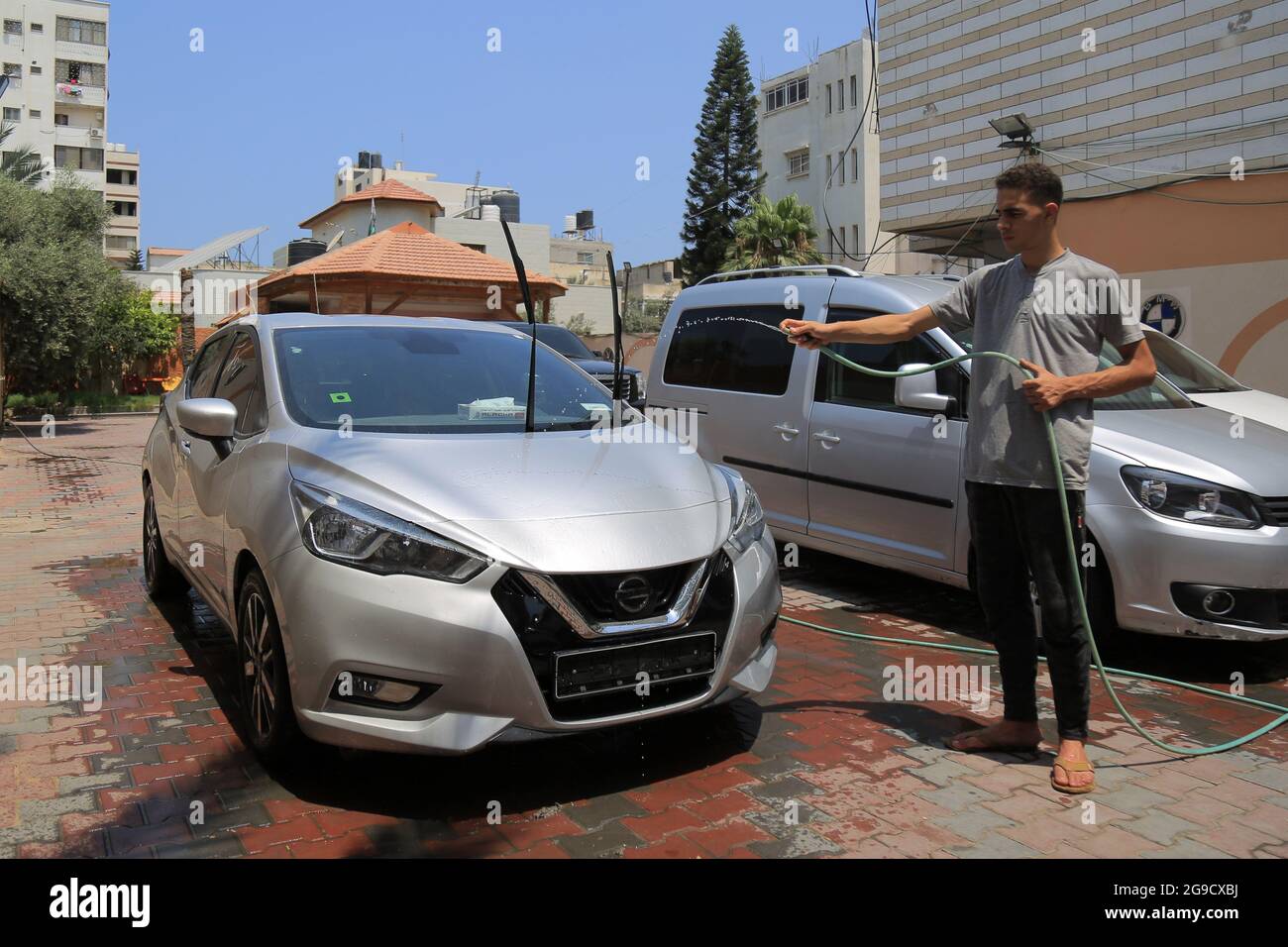 Gaza. 25th July, 2021. A Palestinian man cleans a new car at a car show ...