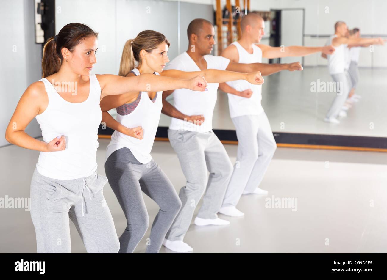 Group of people practicing self defense movements in training room ...