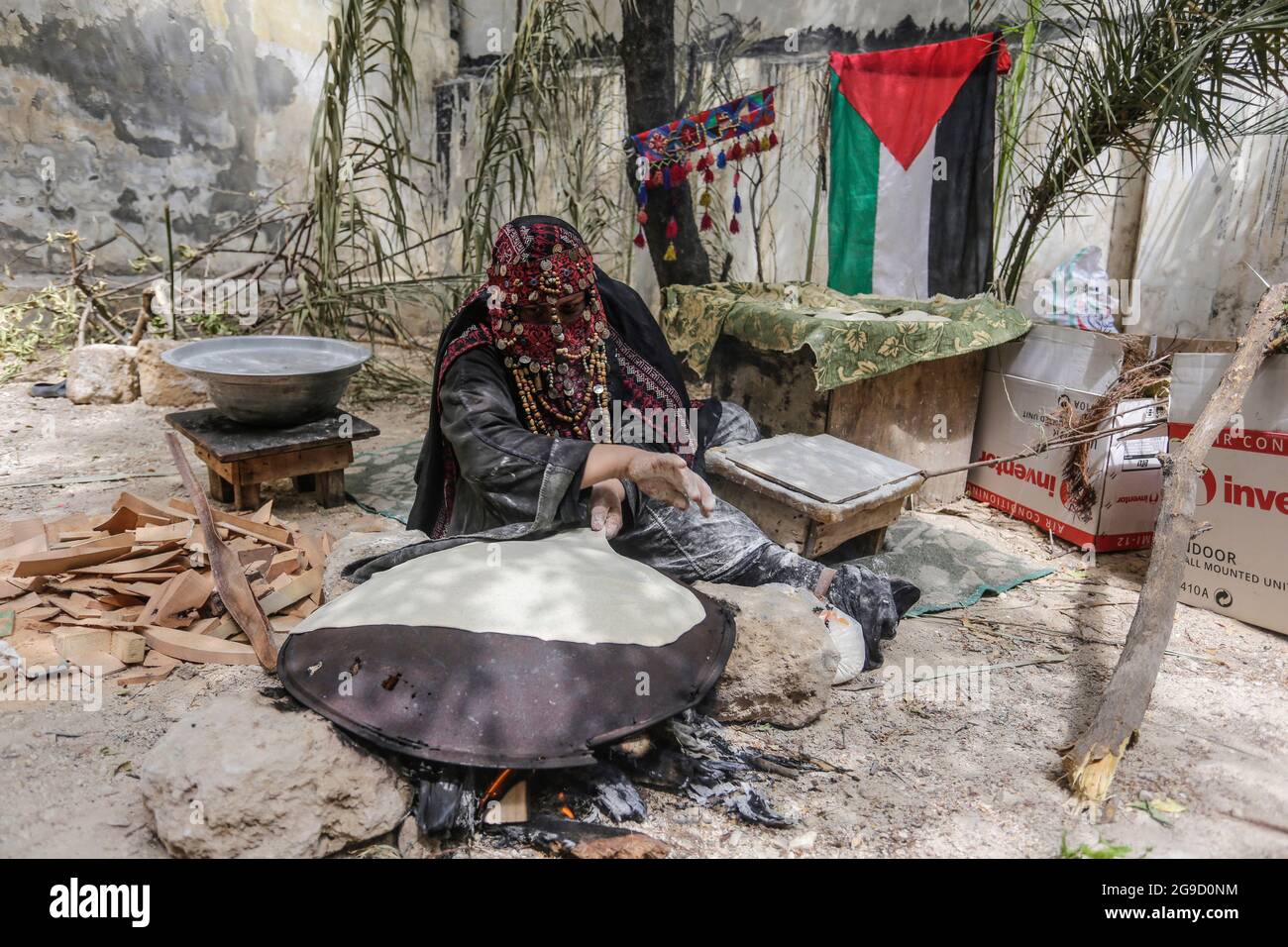 A Palestinian woman bakes Palestinian saj during the exhibition ...