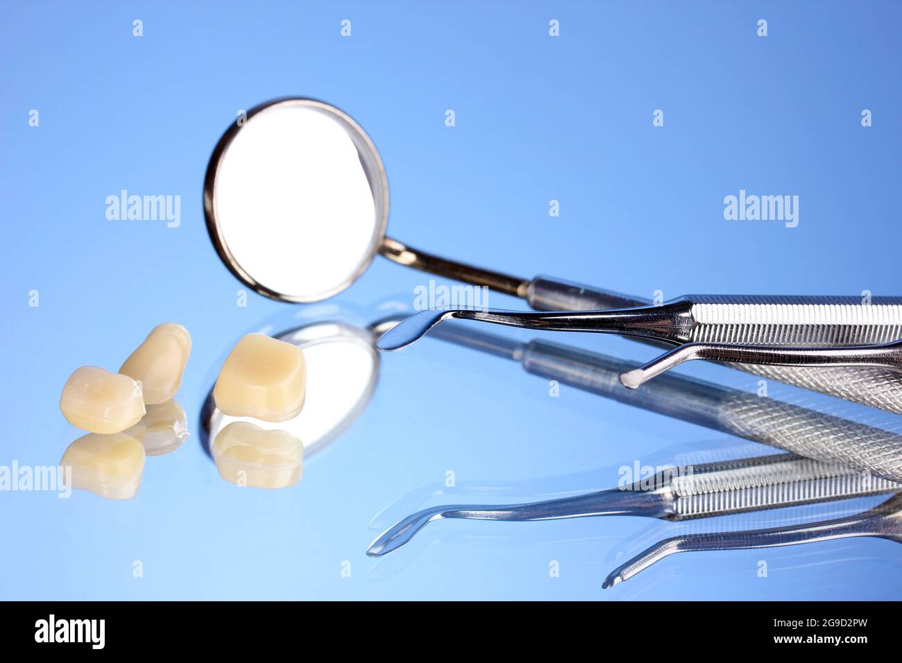 dental mirror with denture teeth on blue background Stock Photo - Alamy