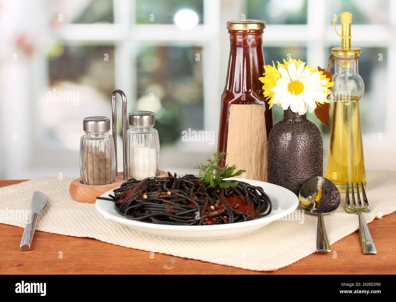 Black spaghetti on bright background Stock Photo - Alamy