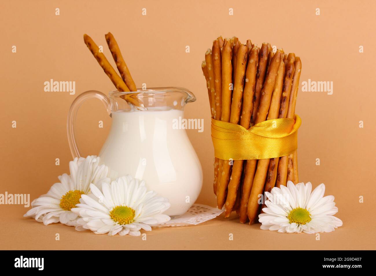 Tasty crispy sticks with pitcher with sour cream on beige background ...