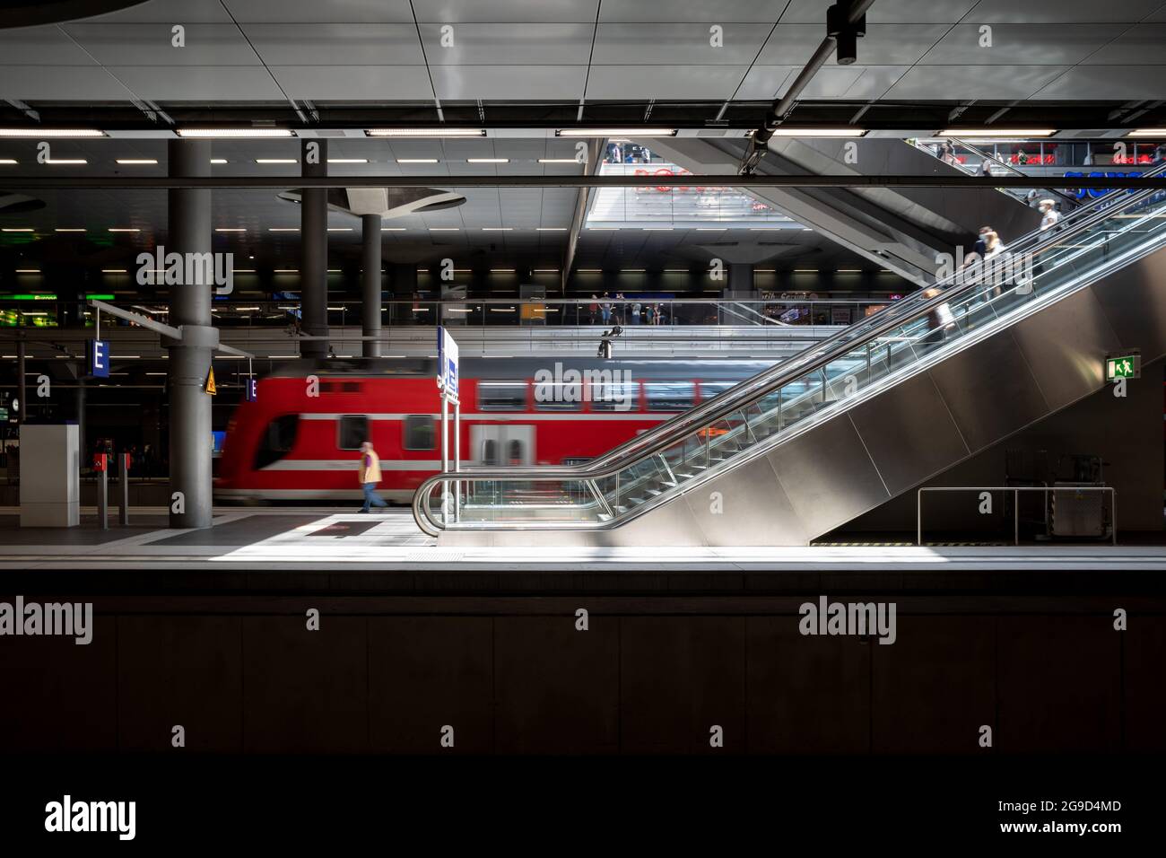 Interior view of platform railway station with escalator, passengers ...