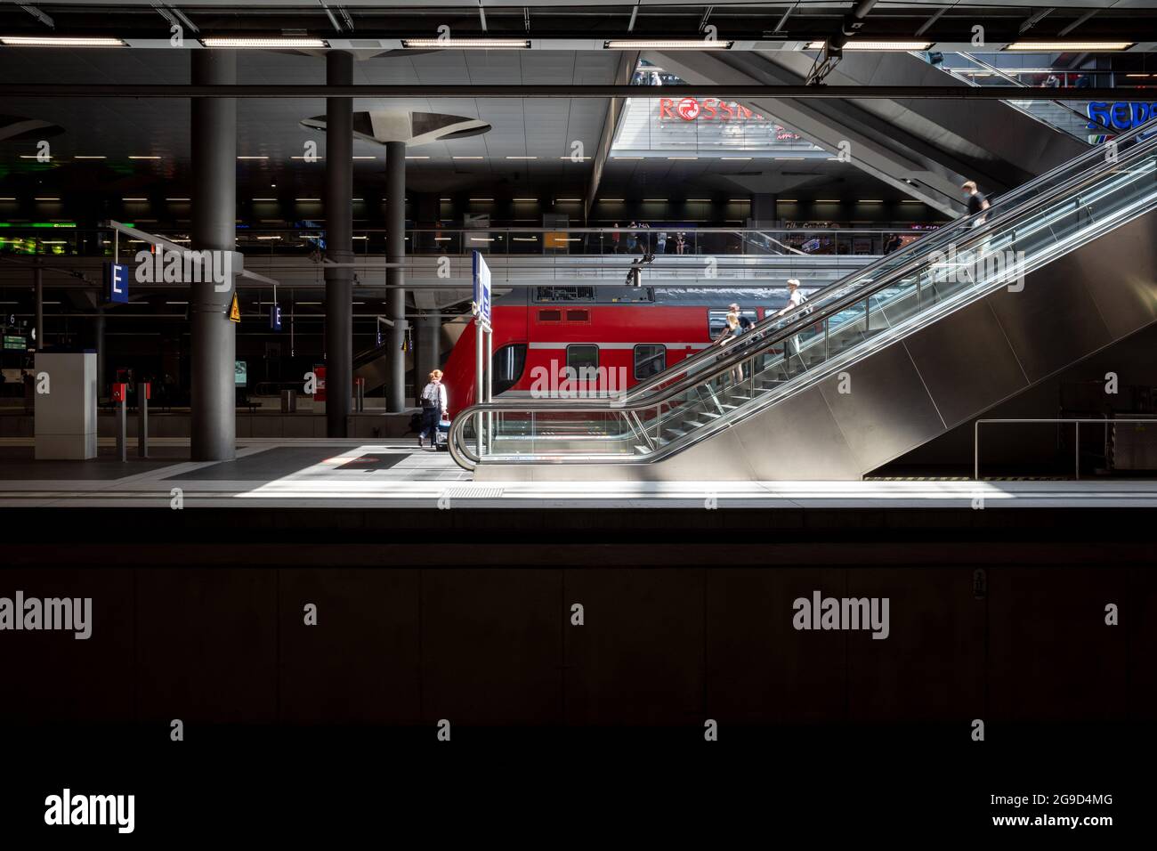 Interior view of platform railway station with escalator, passengers ...