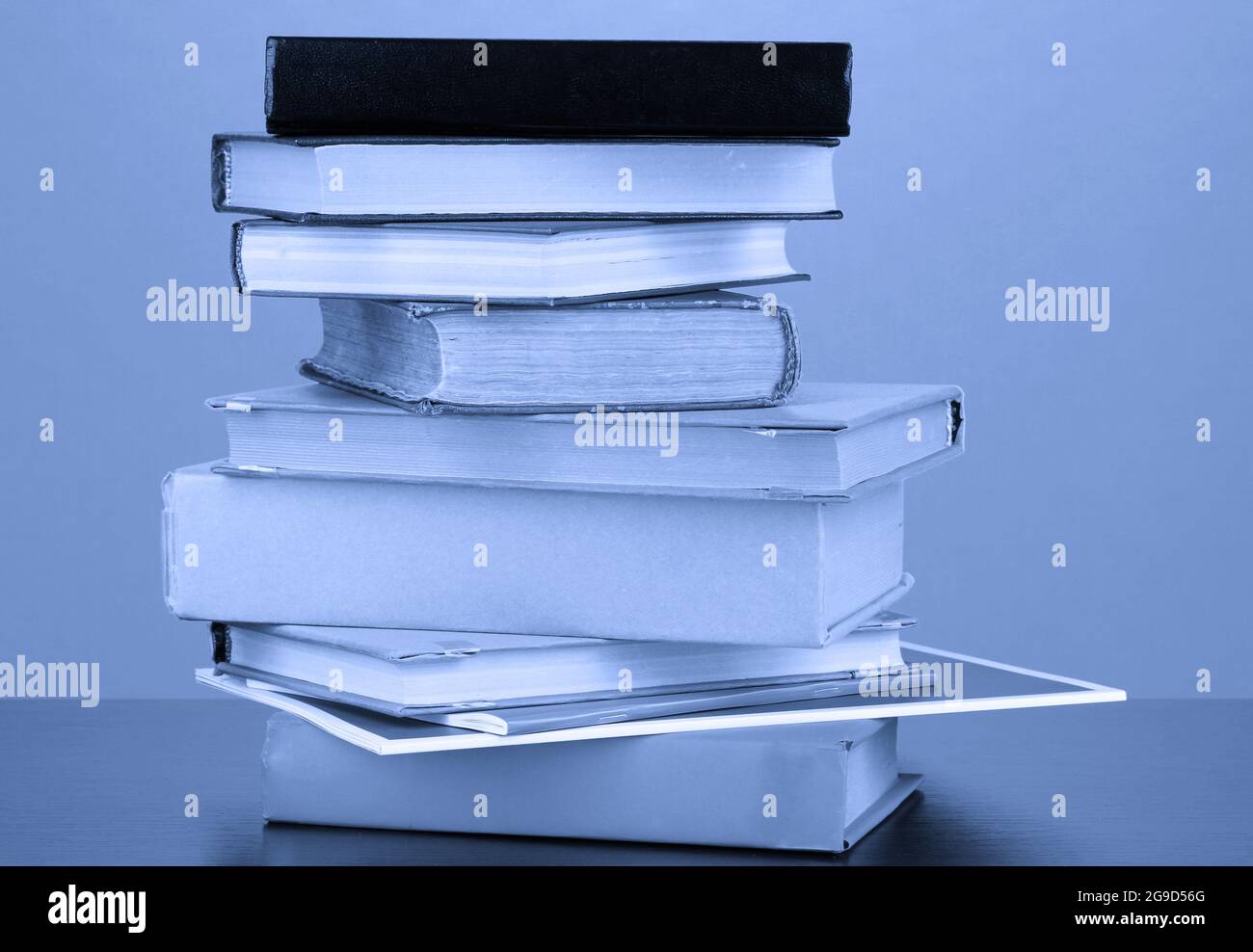 Stack of books in dark blue light Stock Photo - Alamy
