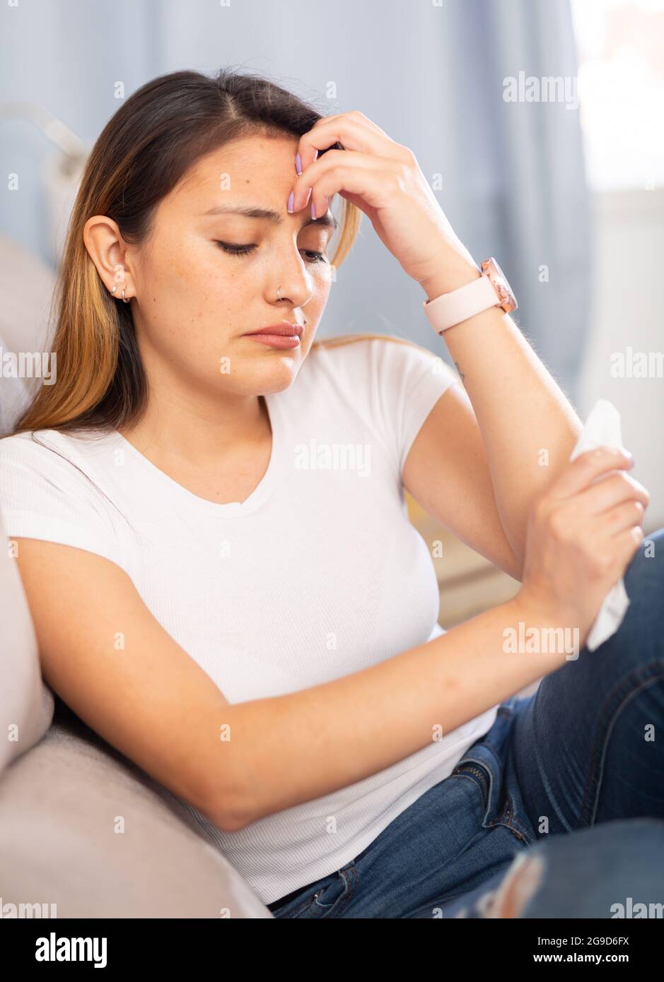 Painful woman sitting on sofa hi-res stock photography and images - Alamy