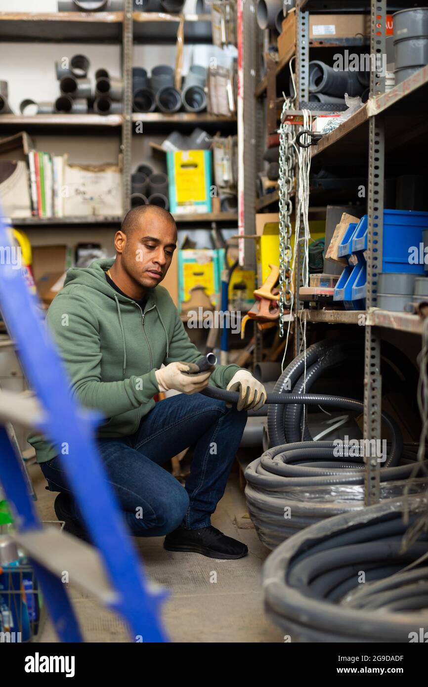 Man choosing plastic pipes in plumbing store Stock Photo - Alamy