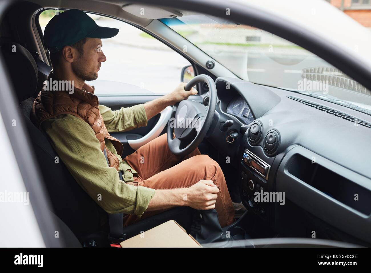 Side view portrait of adult man driving van while delivering parcels ...
