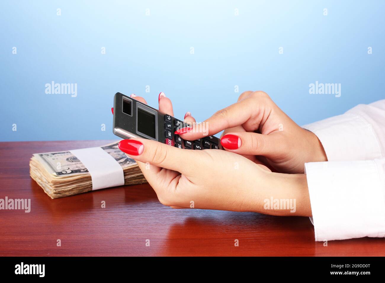 female hands doing calculations on calculator on blue background Stock ...