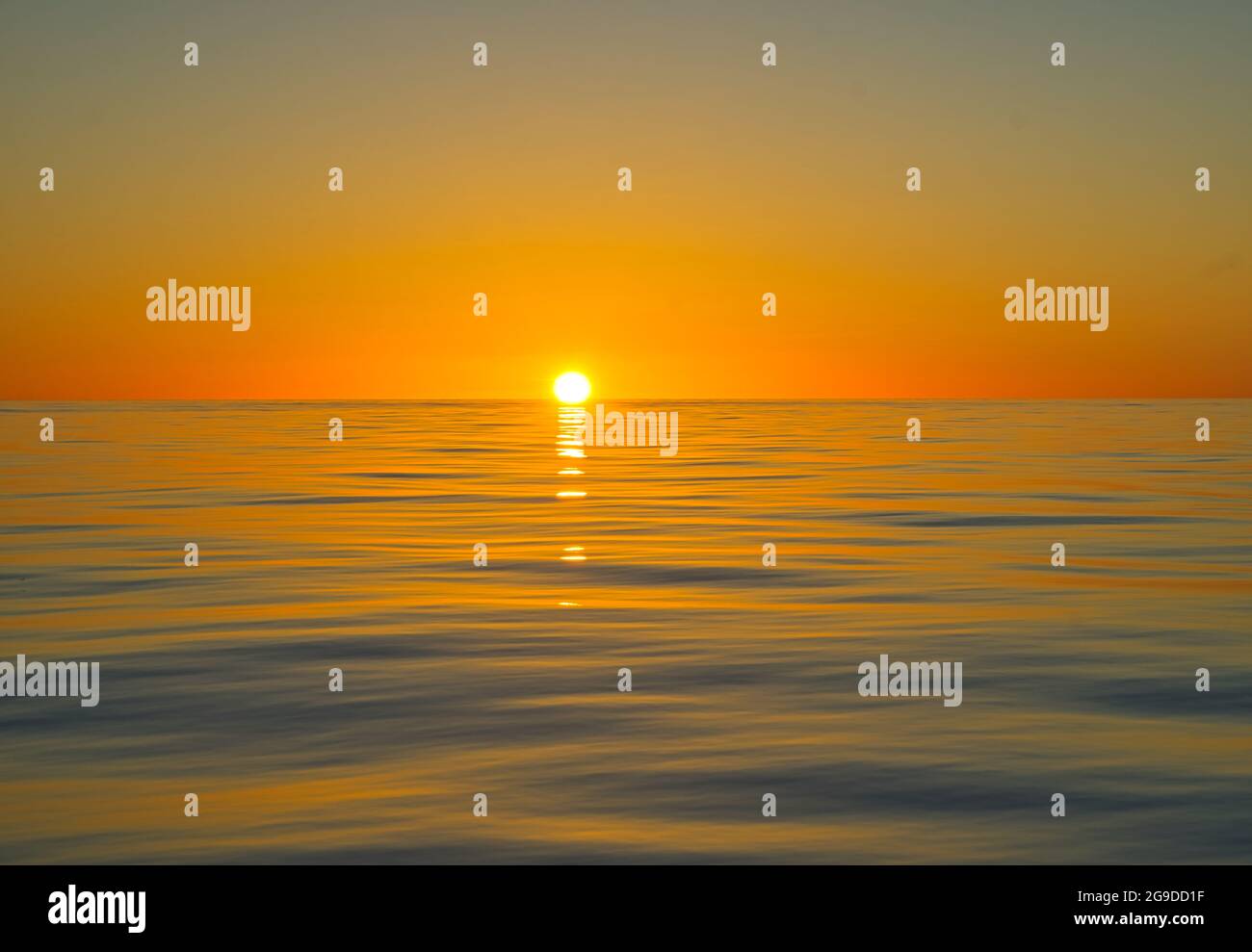 The sun rises from the sea level. Dark clouds above the sun. Sunrise ...