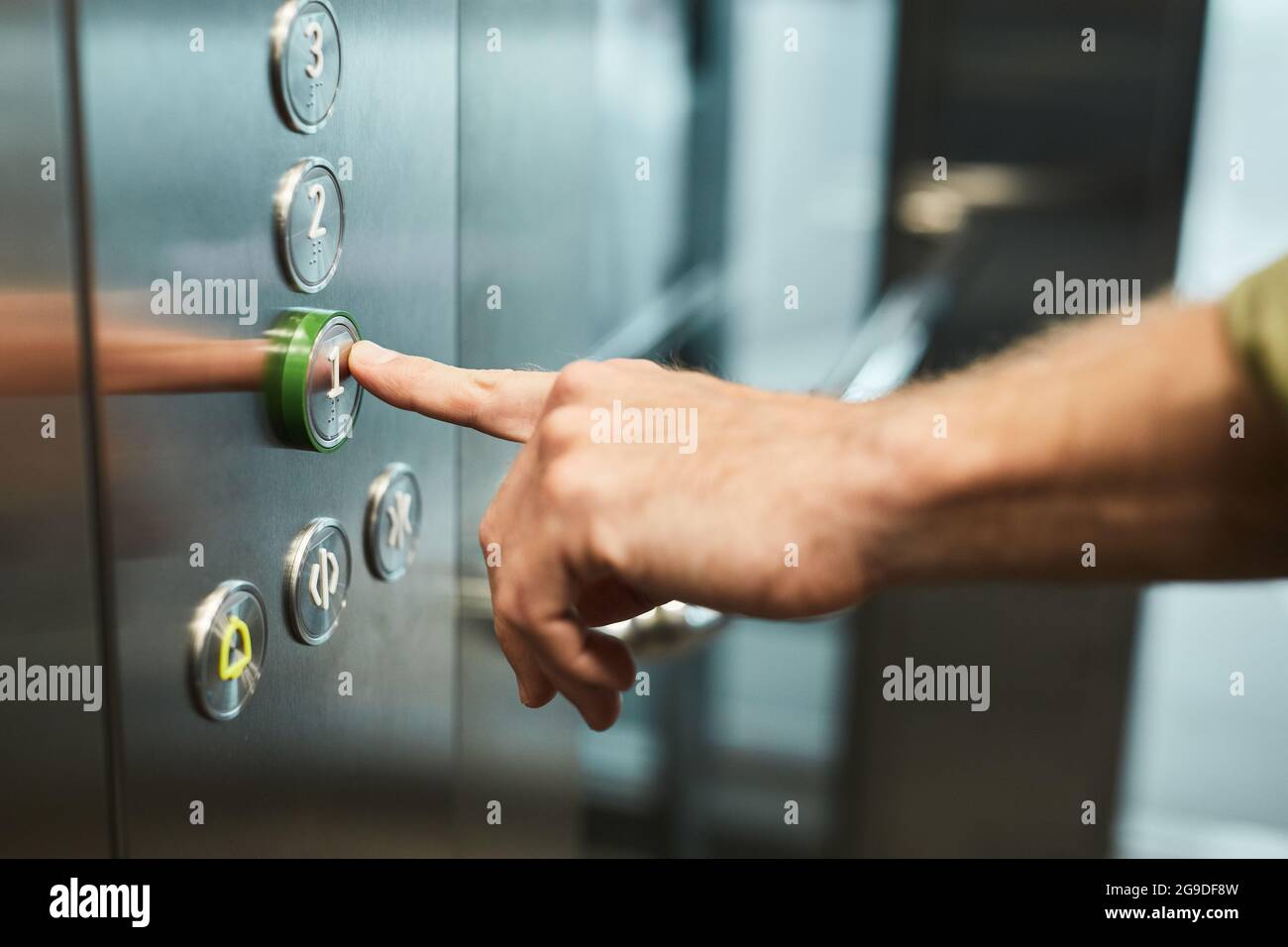 Close up of unrecognizable man pushing buttons in elevator, copy space ...
