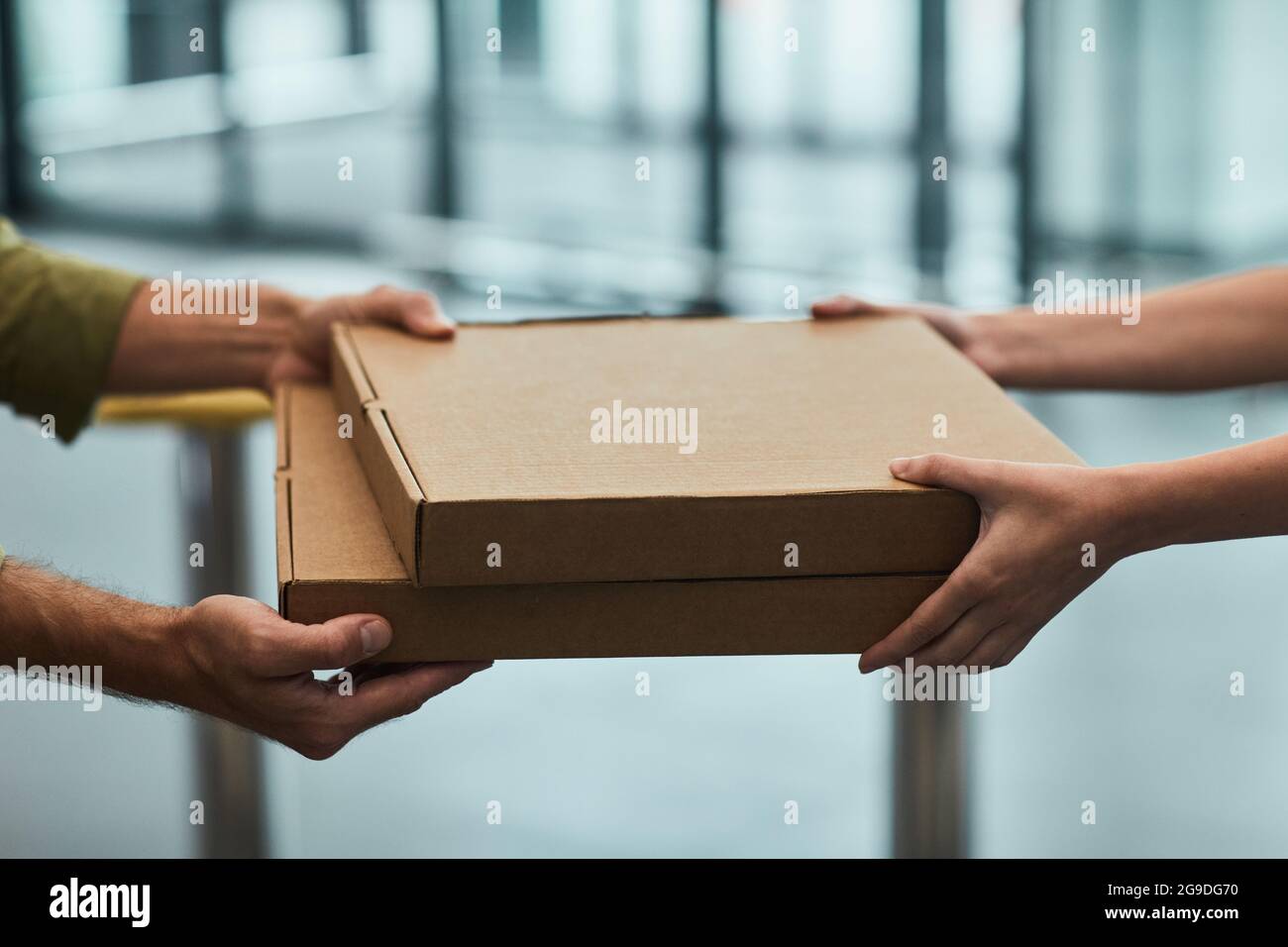 Side view close up of unrecognizable delivery man handing pizza to ...
