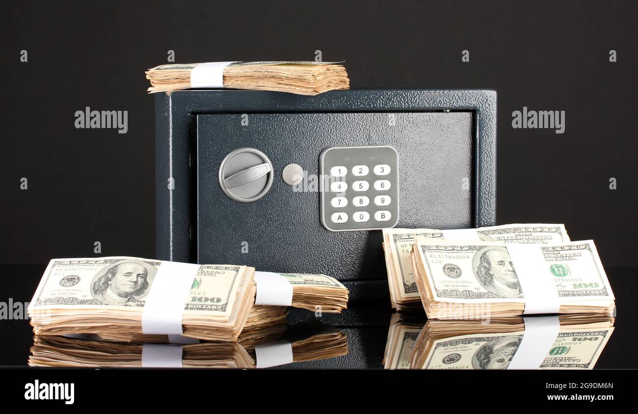 American dollars and safe isolated on black Stock Photo - Alamy