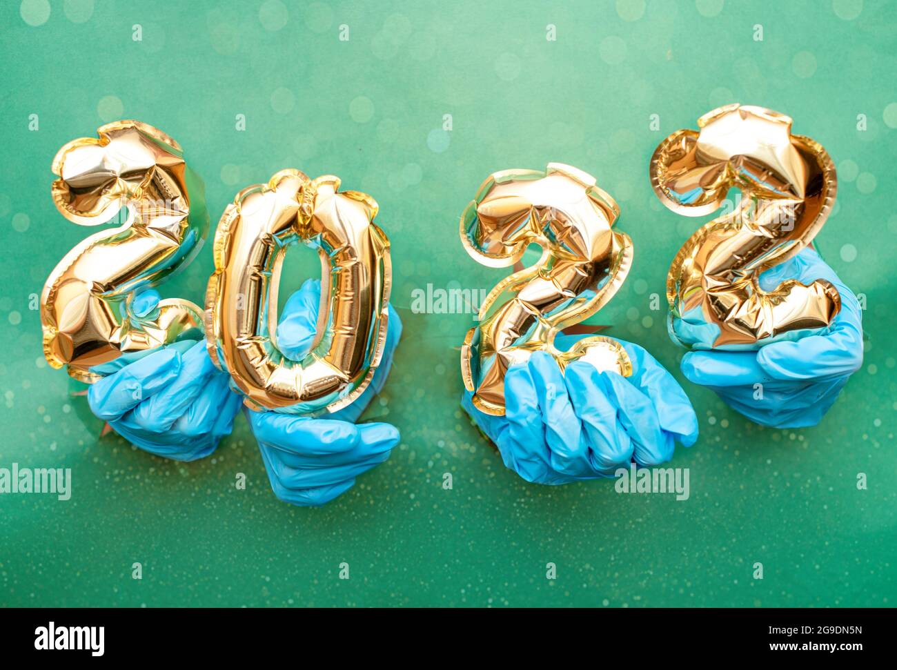 Hands in medical gloves hold festive Christmas figures for the year ...