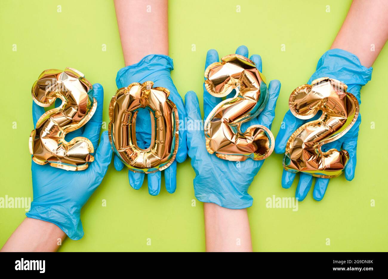 Hands in medical gloves hold festive Christmas figures for the year ...