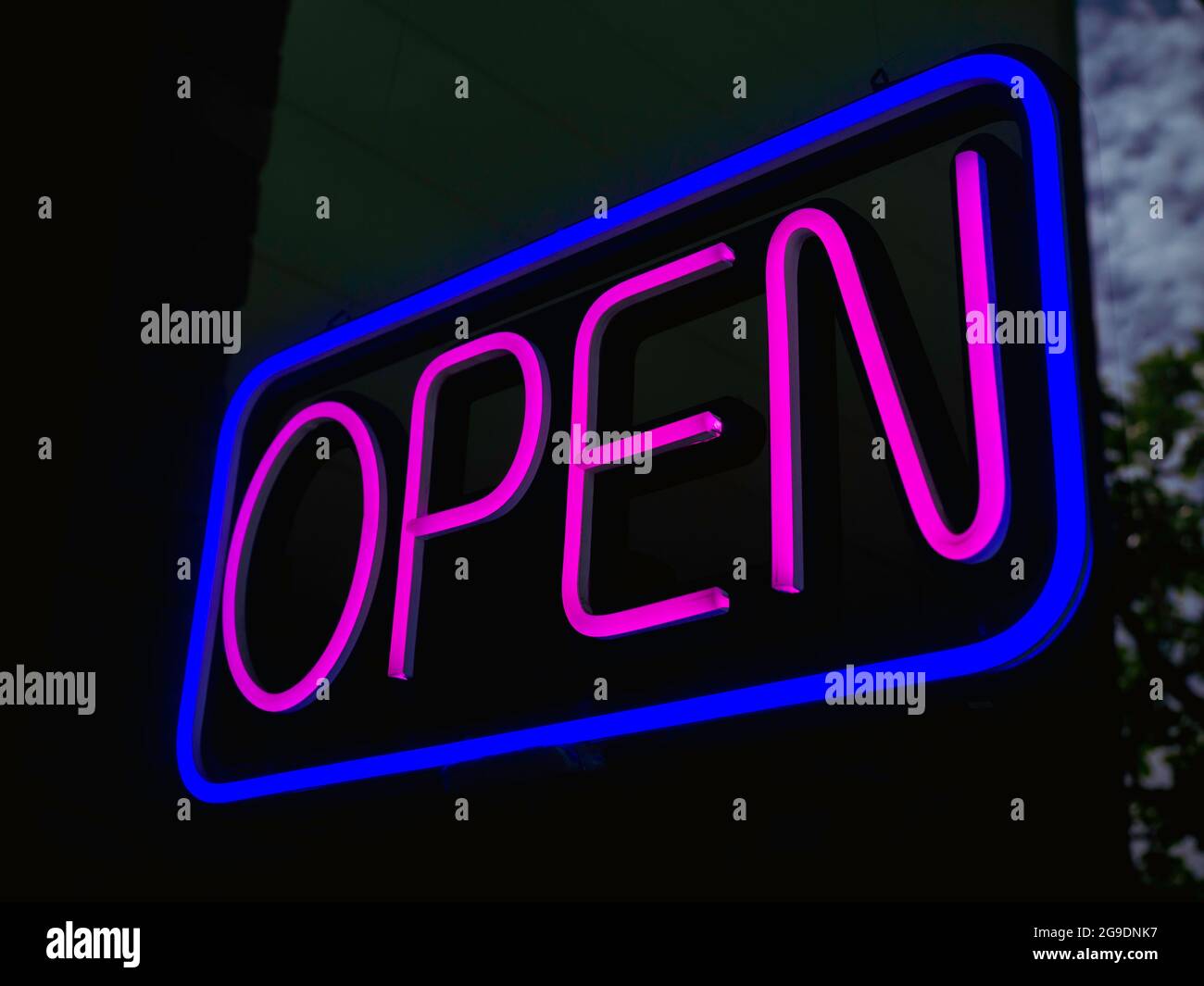 OPEN neon sign on glass at the entrance to bar or cafe, dark background ...