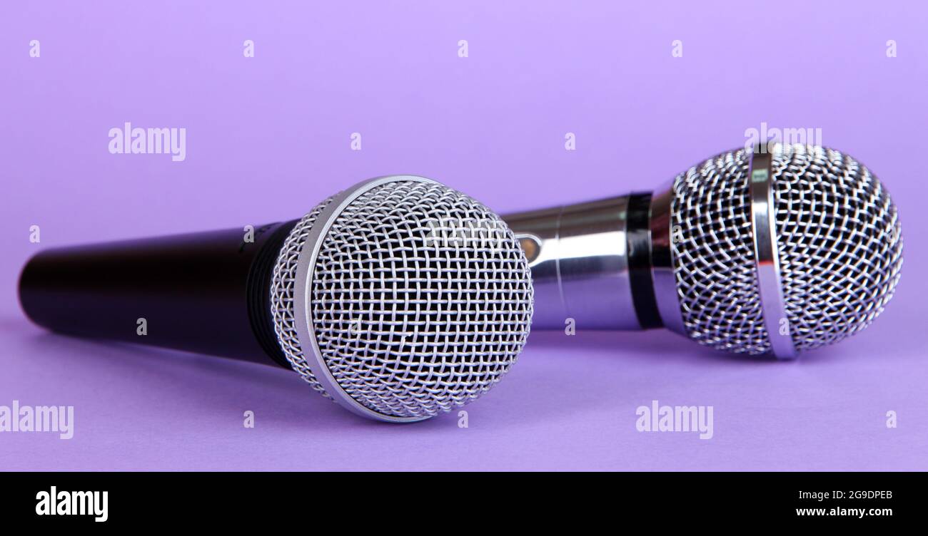 Silver and black microphones on purple background Stock Photo - Alamy
