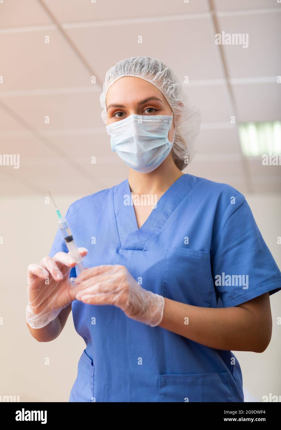 Female nurse in mask holding syringe for injection Stock Photo - Alamy