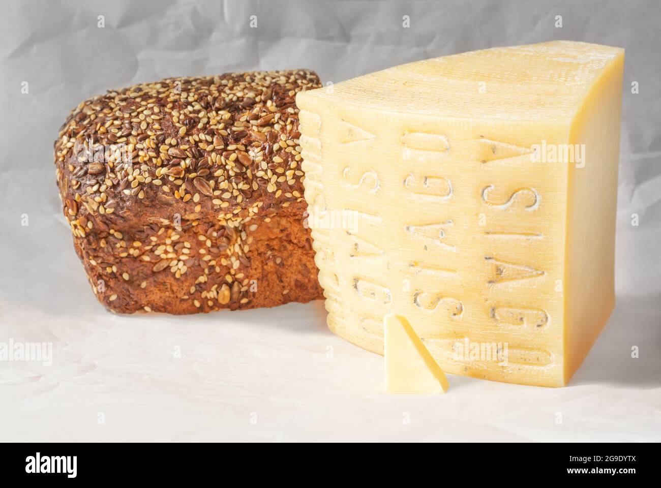 Part of a head of asiago cheese and a small piece of butter on a ...