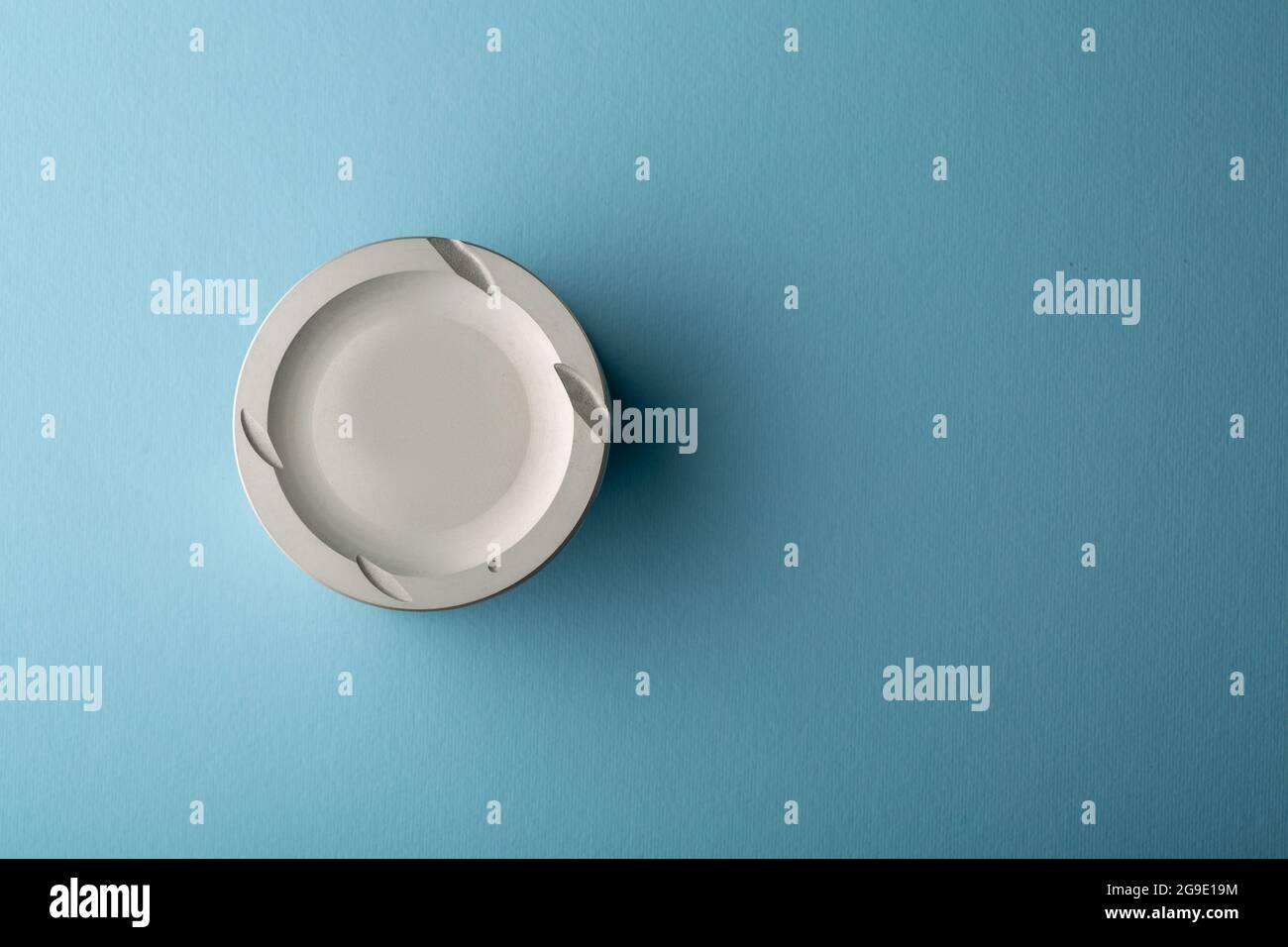 Piston from a car engine on the blue background with copy space ...