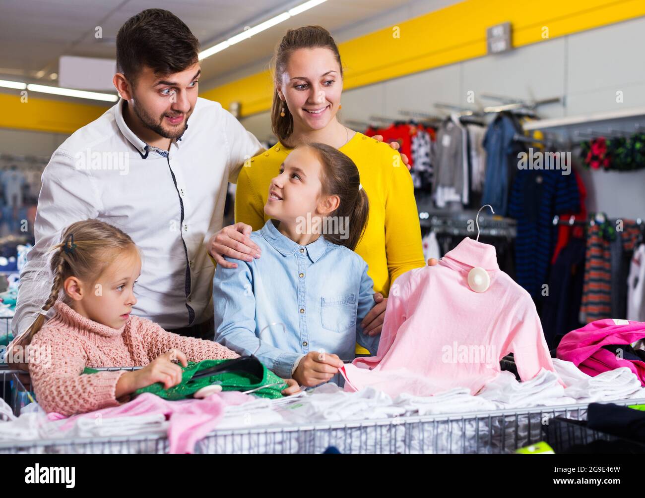 family with two girls choosing new clothes Stock Photo - Alamy