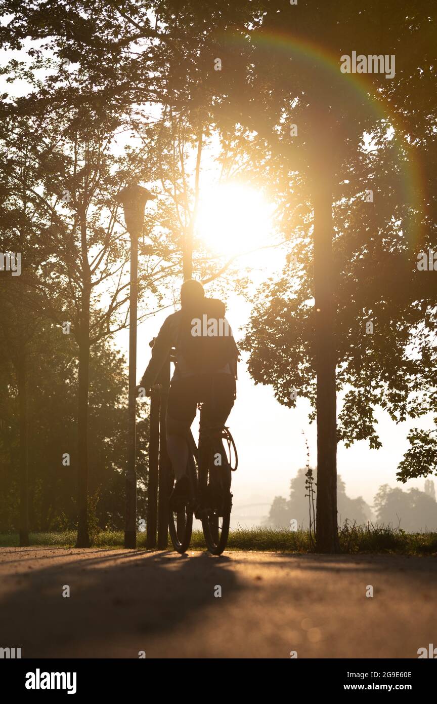 Dresden, Germany. 26th July, 2021. A cyclist is silhouetted against the ...