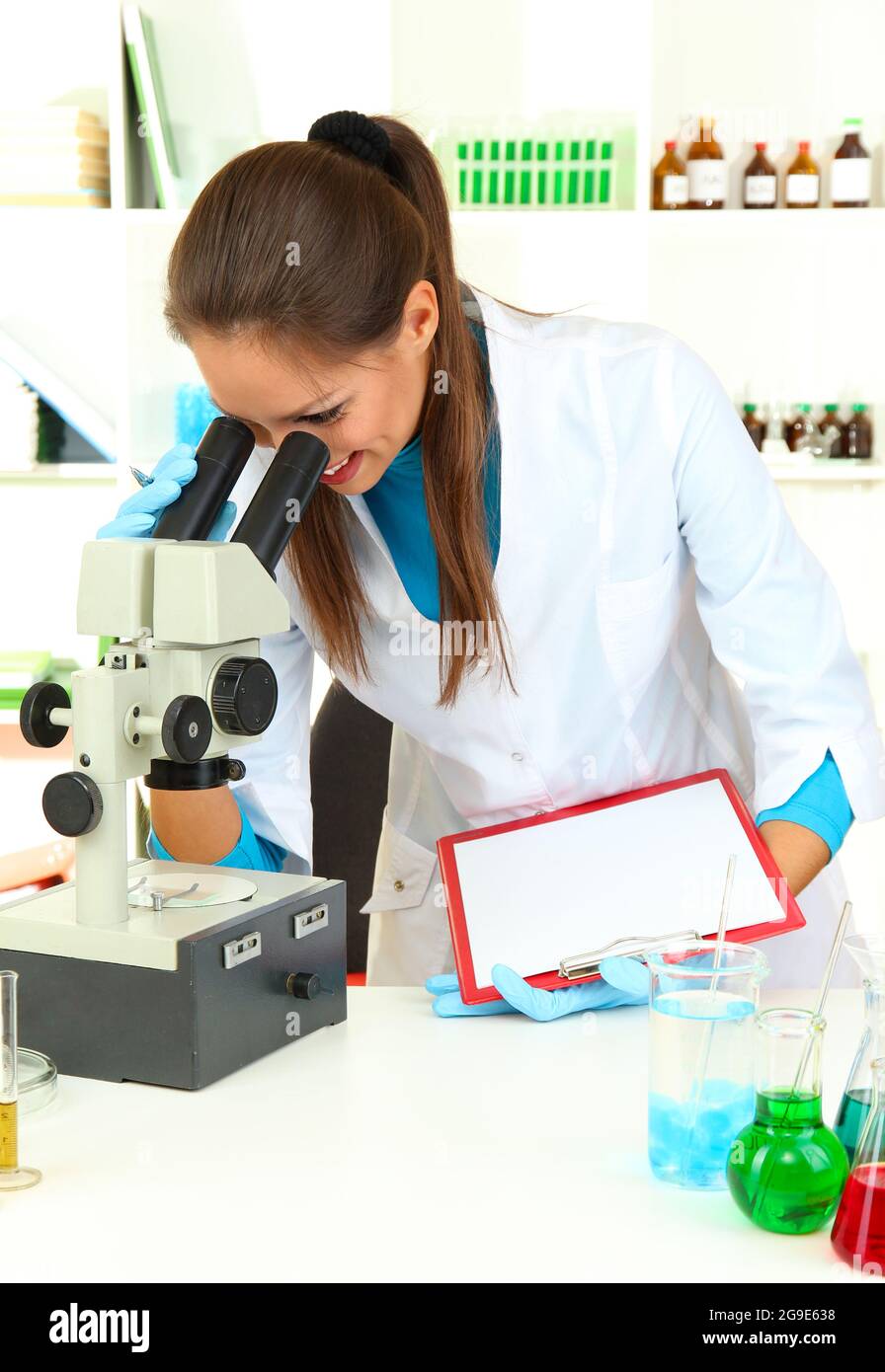 Young scientist looking into microscope in laboratory Stock Photo - Alamy