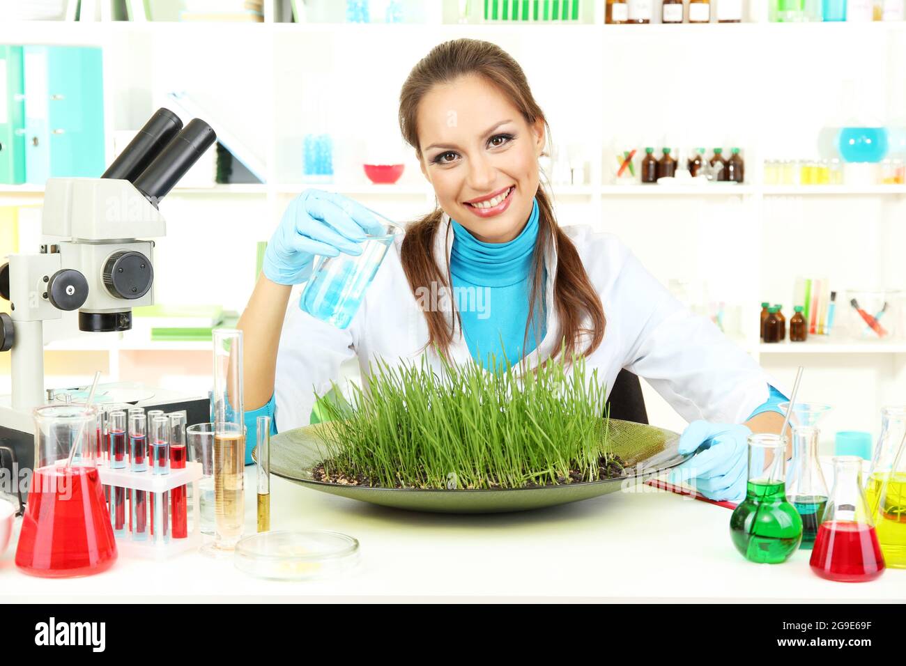 Young female scientist is conducting experiments with plants in ...