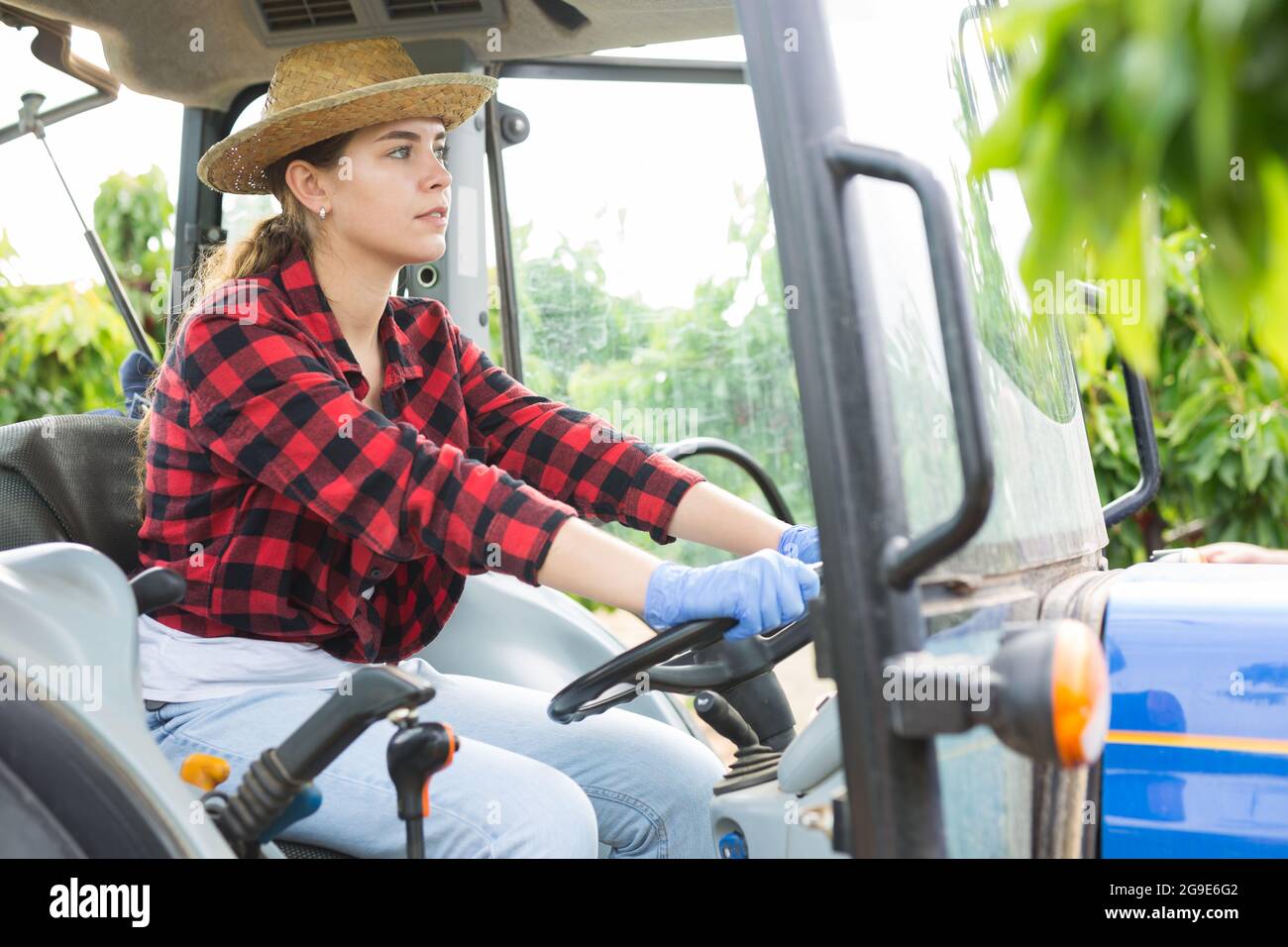 Concentrated girl farmer is sitting at the wheel of a tractor Stock ...