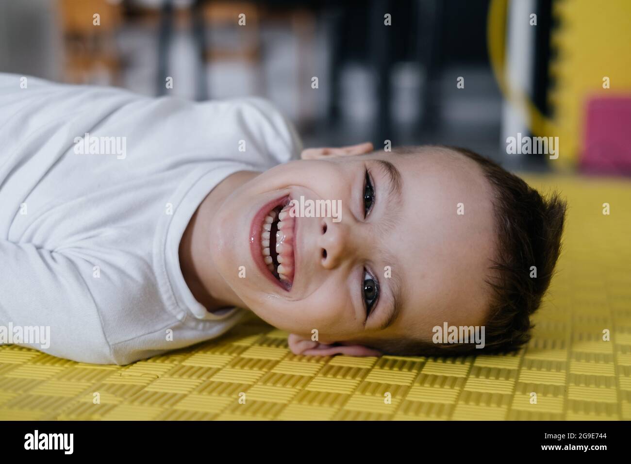 Happy child on the mat in child rehabilitation center. Boy with ...