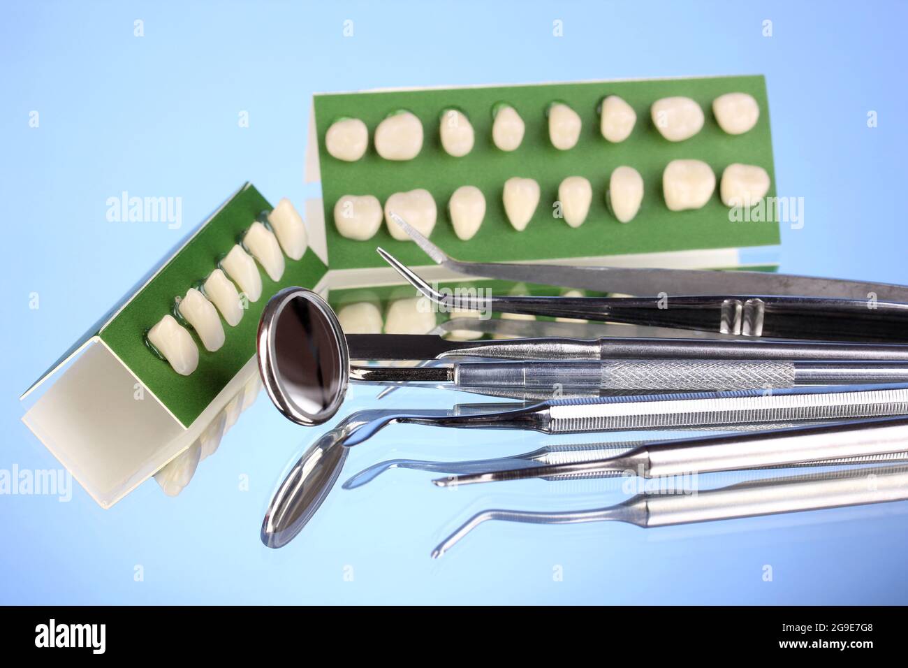 Set of dental tools with denture on blue background Stock Photo - Alamy