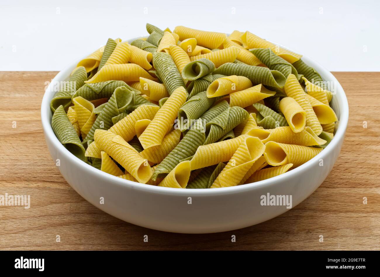 Fresh raw colored pasta. Italian Maccheroni al pettine on wooden table ...