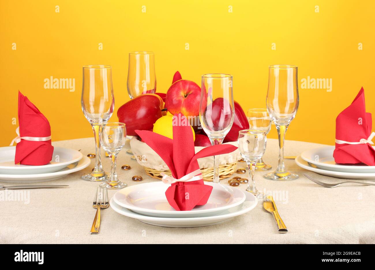 Table setting in red tones on color background Stock Photo - Alamy