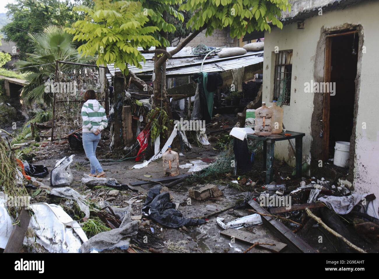 Jalisco, Mexico. 25th July, 2021. A woman walks by a damaged house in ...